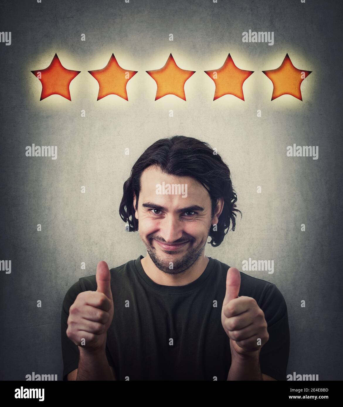 Contented young man, shows both thumbs up gesture, slick smiling to ...