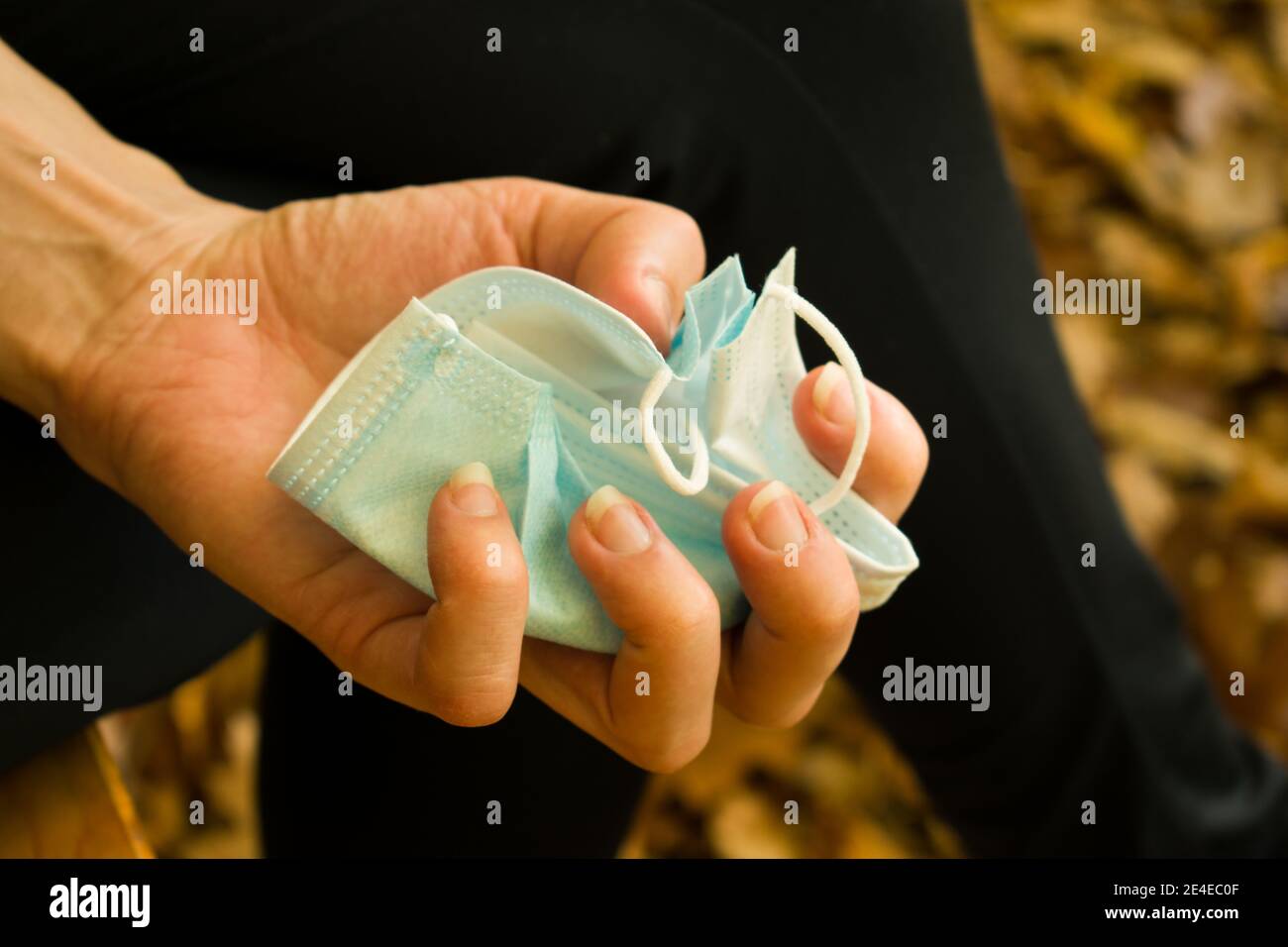 Medical mask crumpled, squeezed and wrinkled by female hand, close up ...