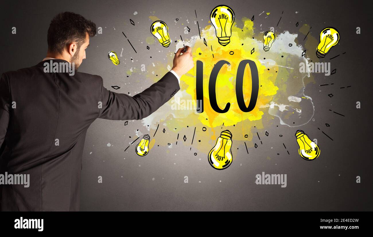 businessman drawing colorful light bulb with ICO abbreviation, new ...