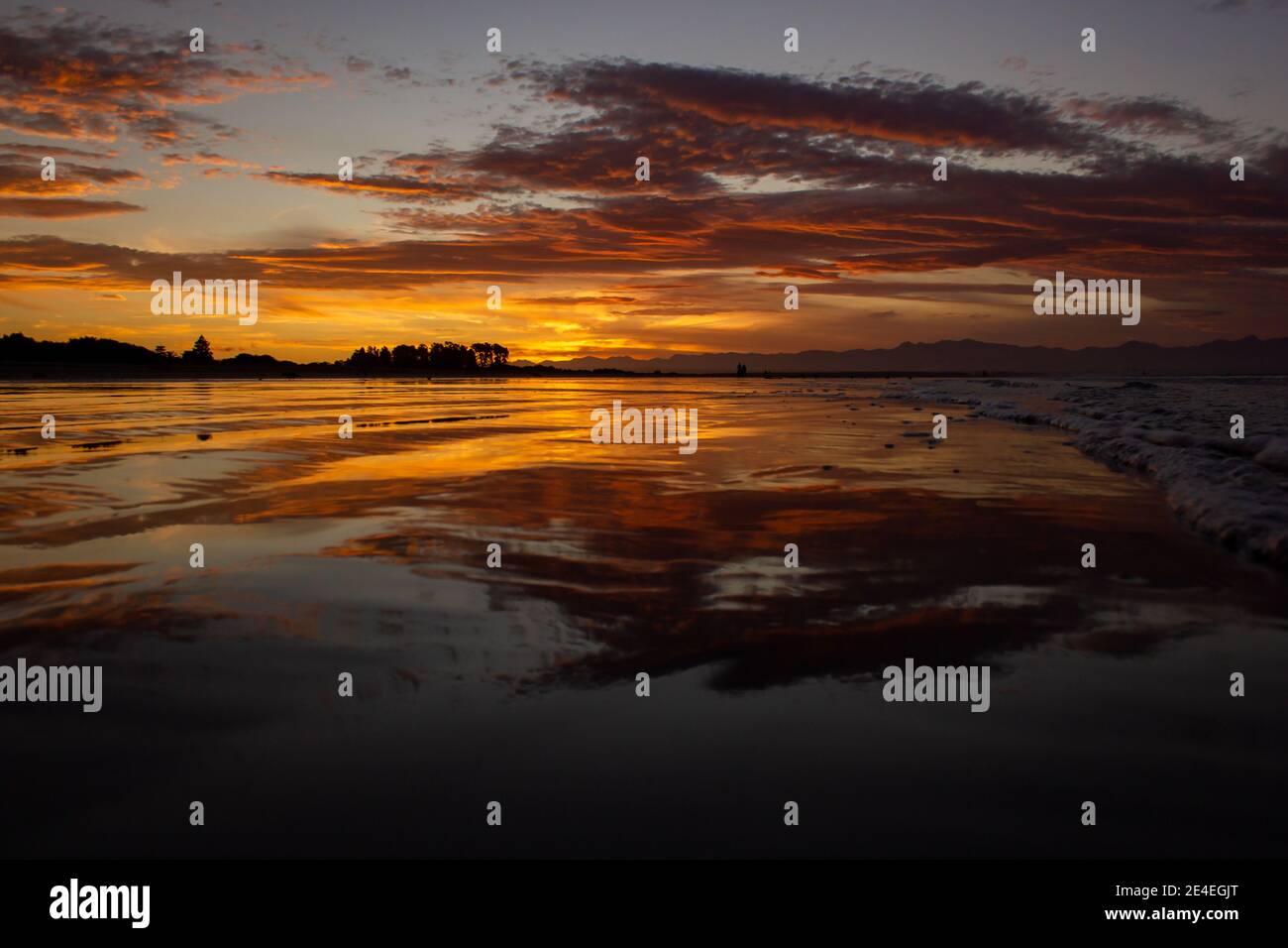 Beach in Nelson during a breathtaking sunset on Tahunanui Beach at ...