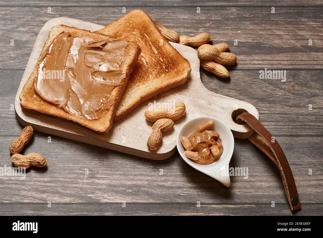 Creamy peanut butter breakfast toast on a wooden kitchen board with ...
