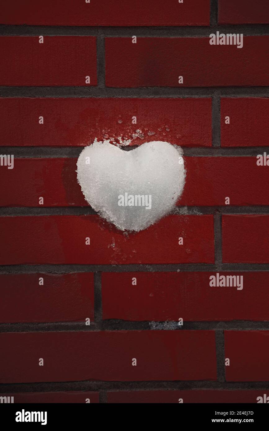 Heart shaped snowball on a red brick wall Stock Photo - Alamy