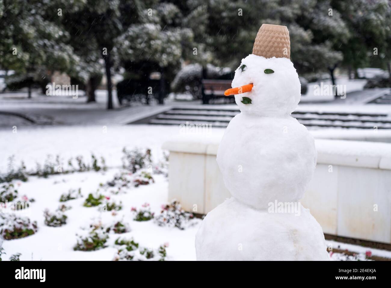 Snowman in city park at winter Stock Photo - Alamy