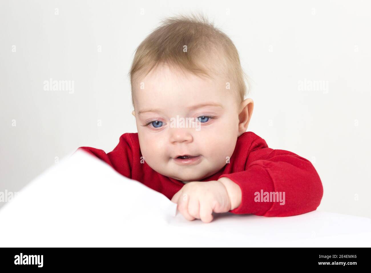 Little kid playing with blank sheets of paper Stock Photo - Alamy