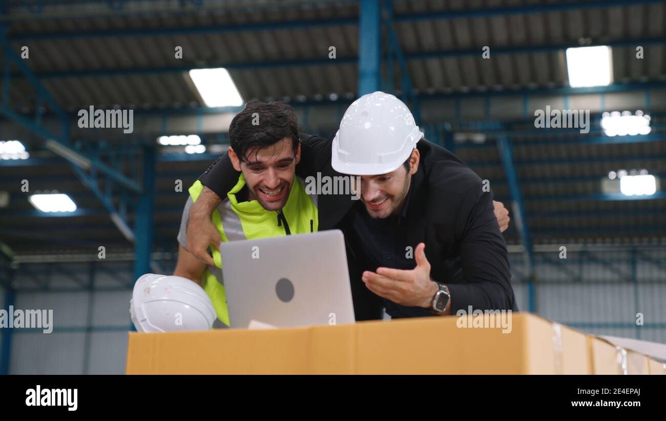 Two factory worker celebrate success together in the factory or ...
