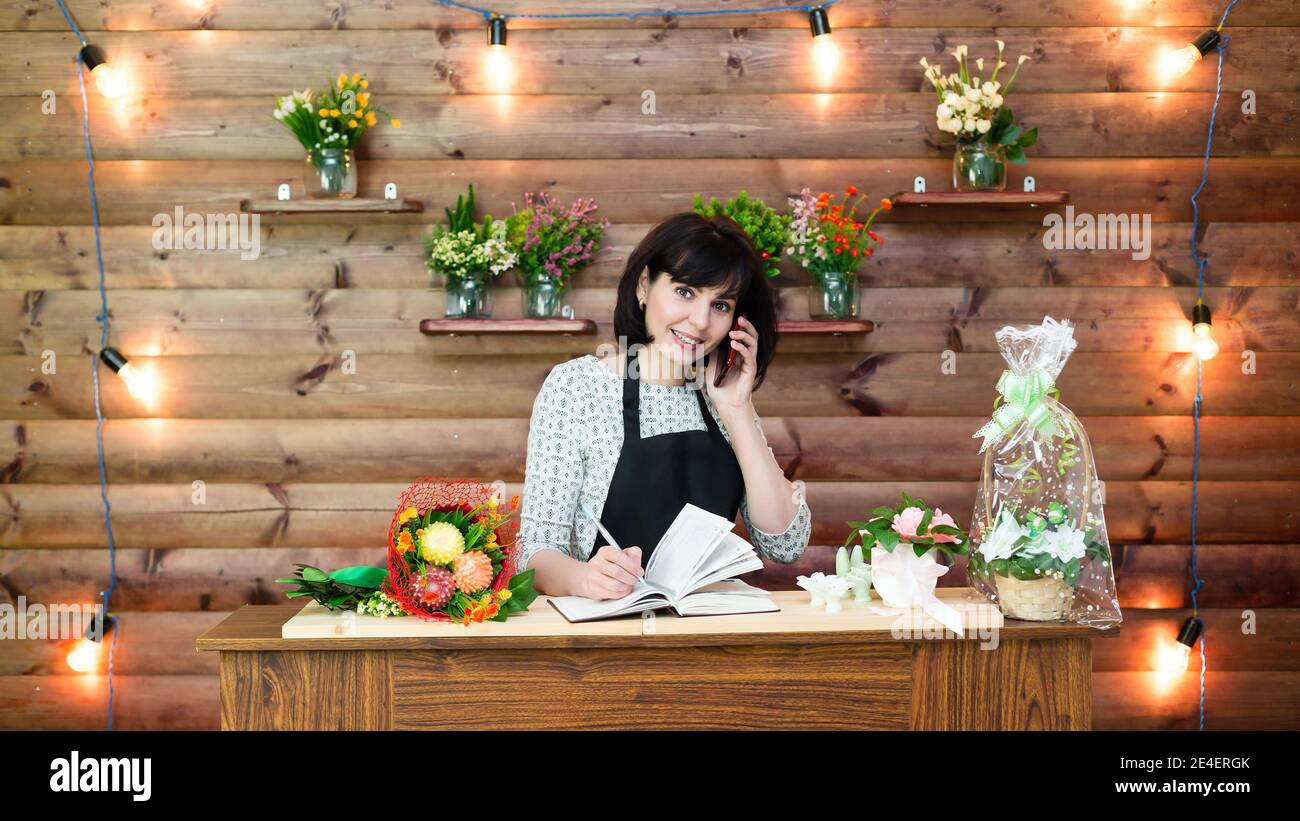 Flower shop assistant talking on the phone with a customer Stock Photo ...