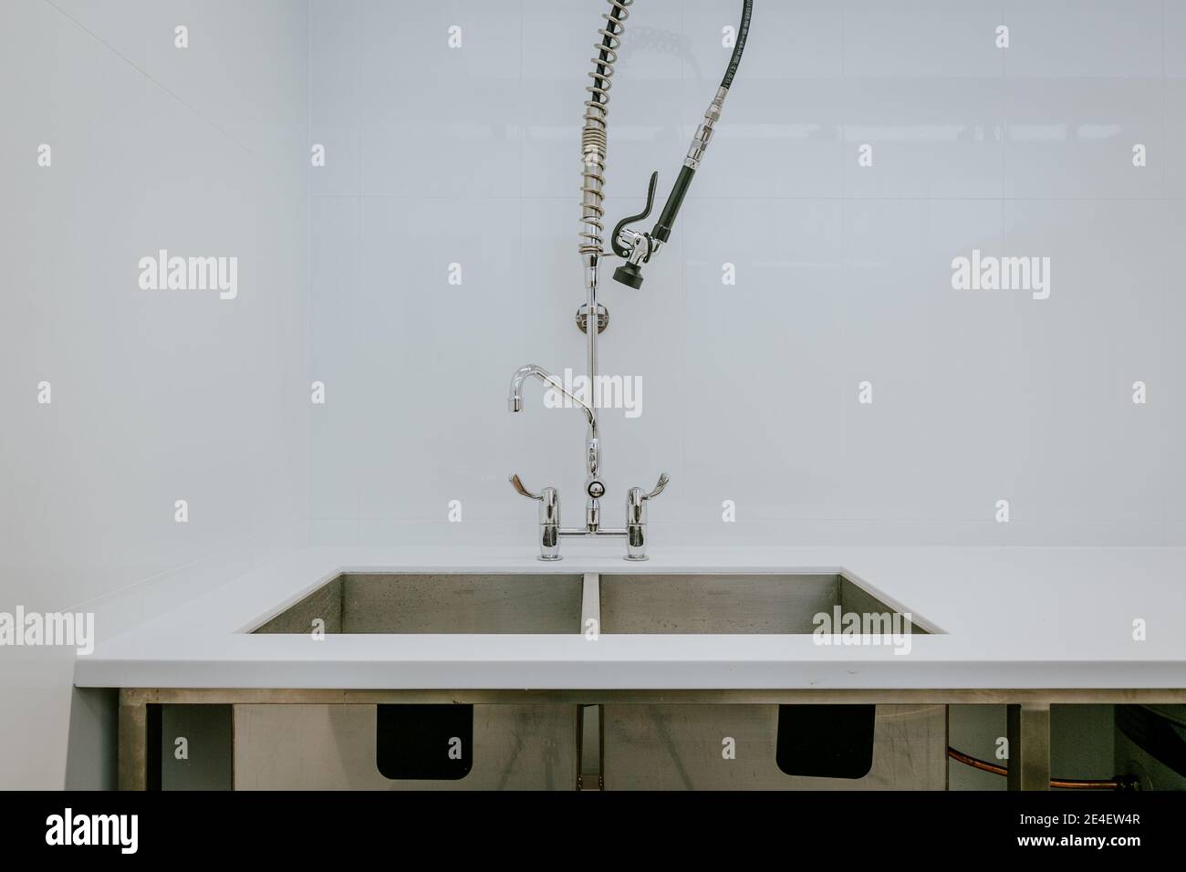New kitchen sink with a long water hose on a white wa Stock Photo - Alamy