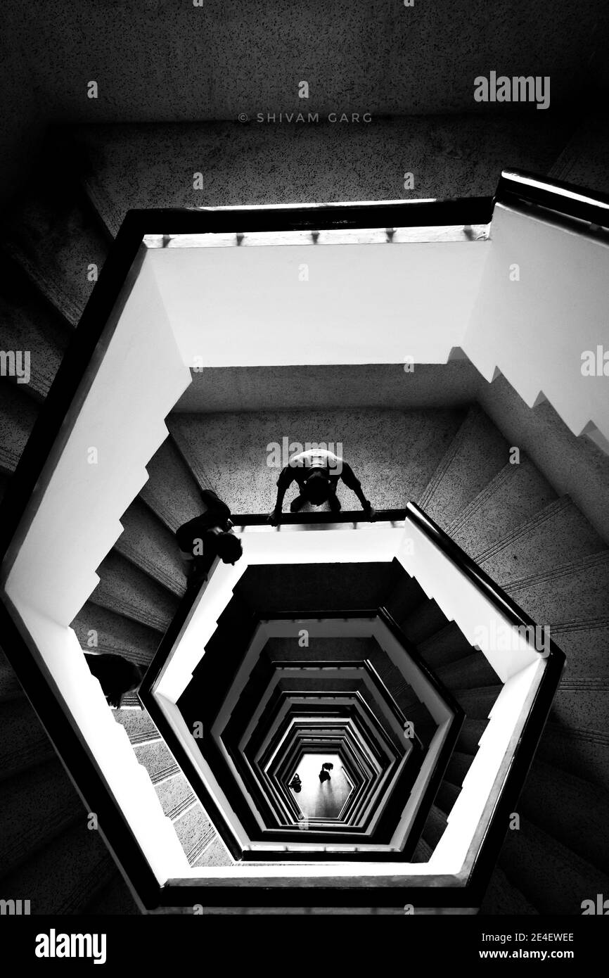 Vertical grayscale top view of a person looking down a geometric ...