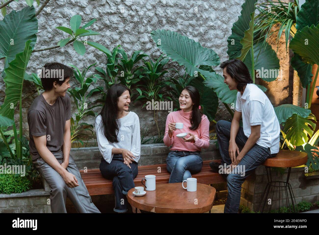 happiness youths chatting while sitting on table and wood bench at home ...