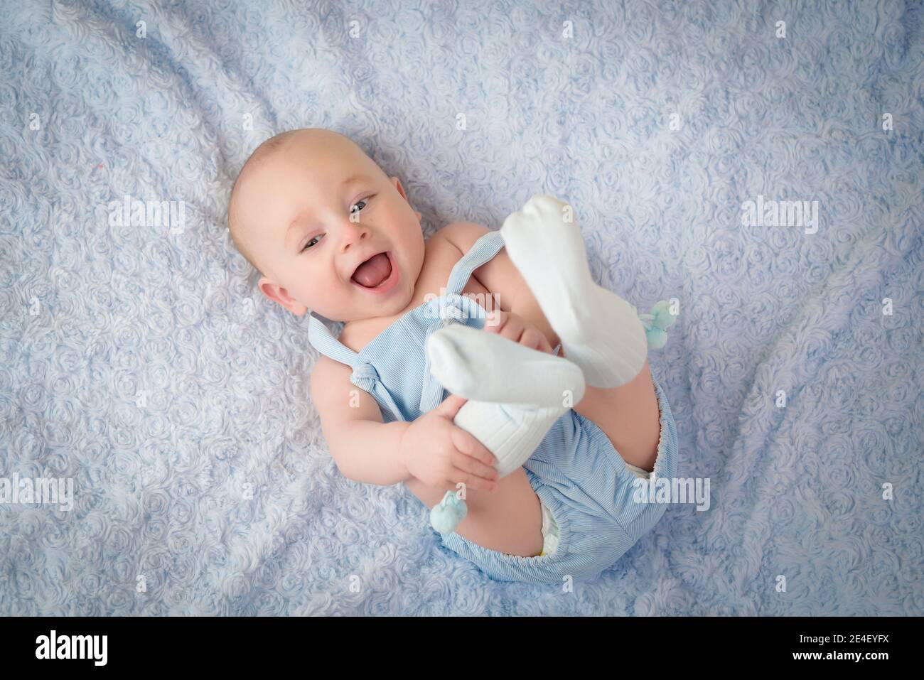 happy and smiling baby in blue clothes on blue color background Stock ...
