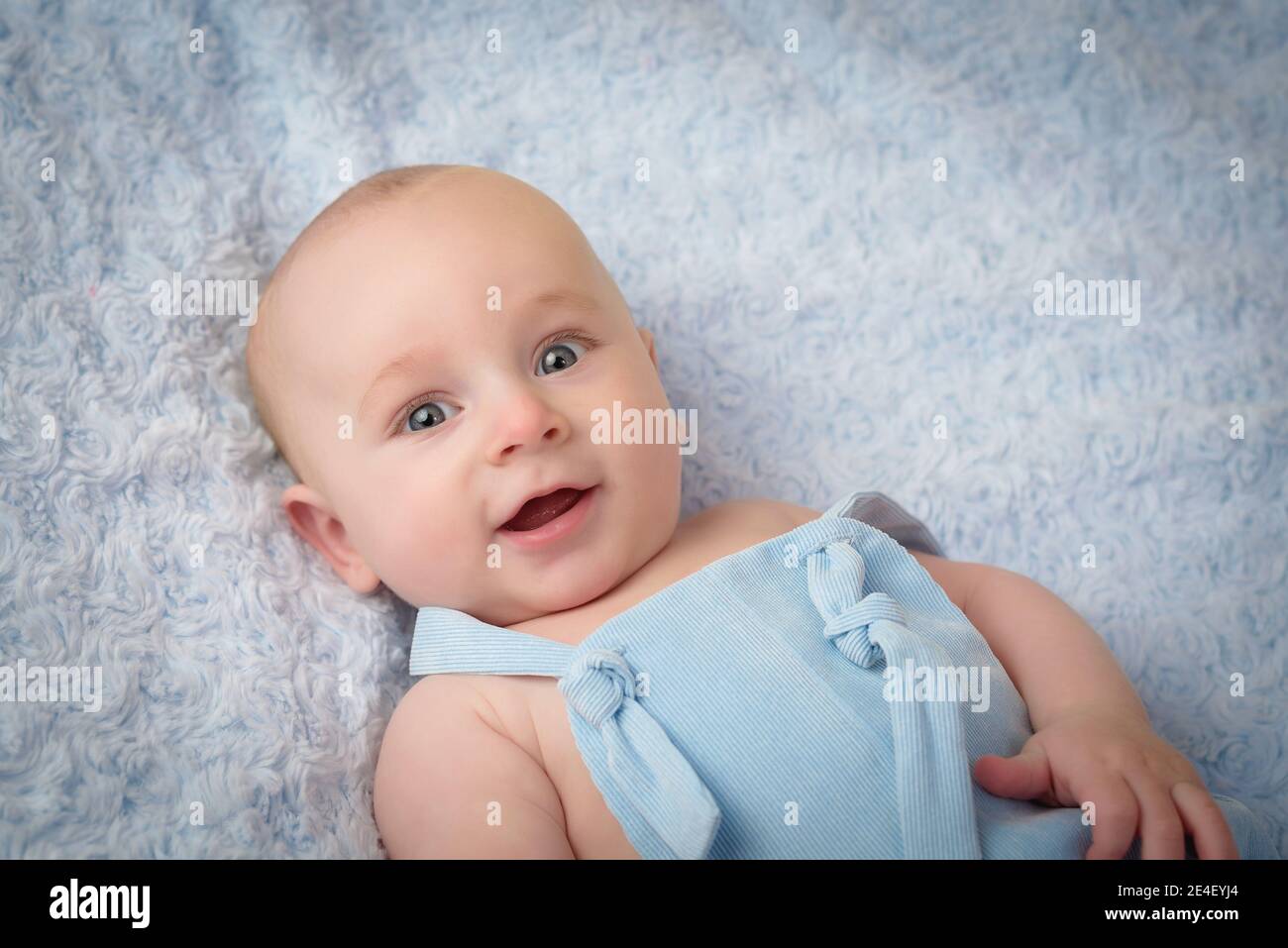 happy and smiling baby in blue clothes on blue color background Stock ...