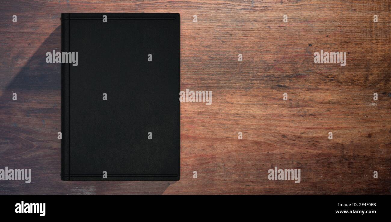 Book blank cover on wooden table background. Closed black cover book ...