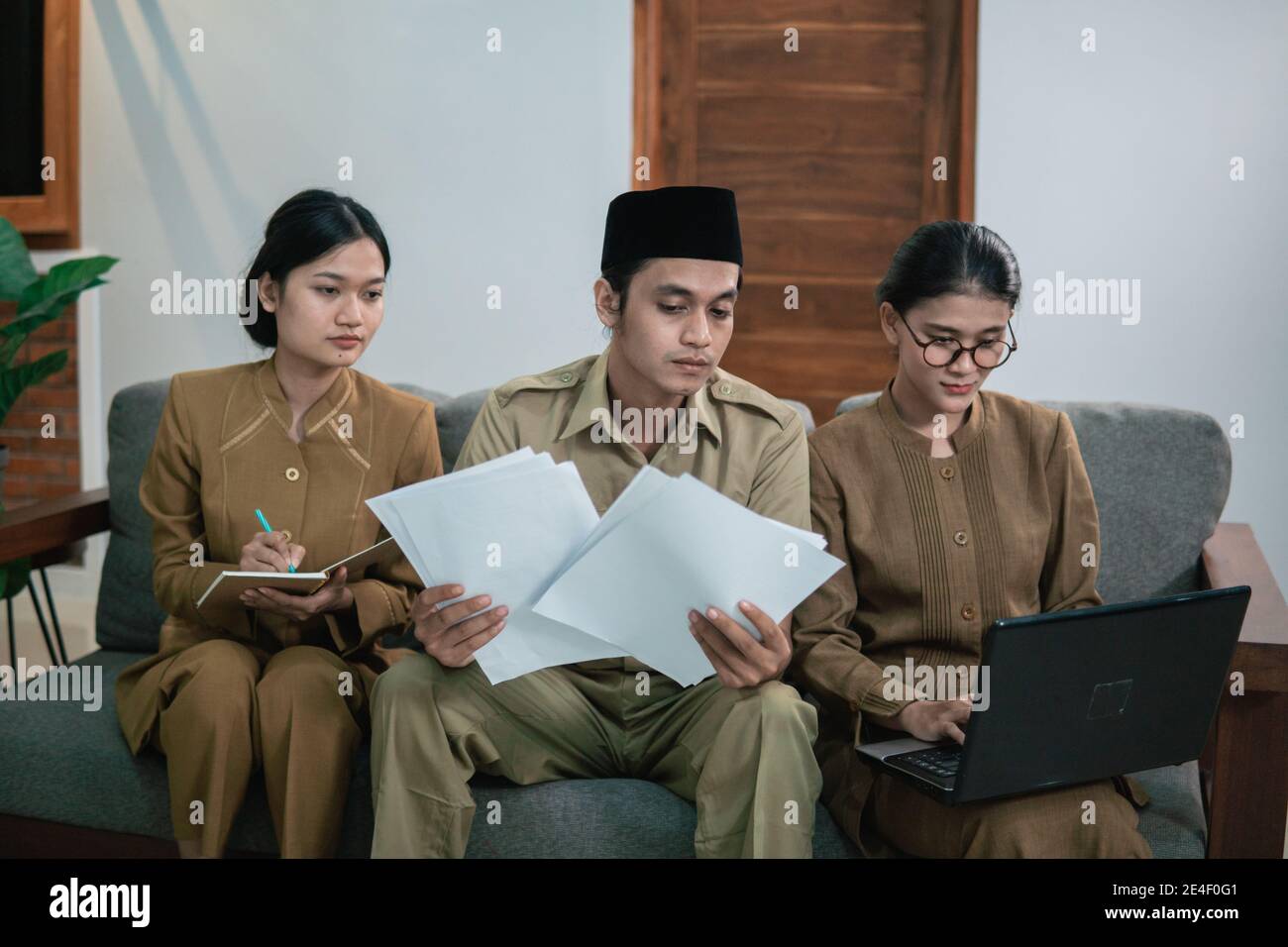 a serious state official holding a paper and two female assistants in ...