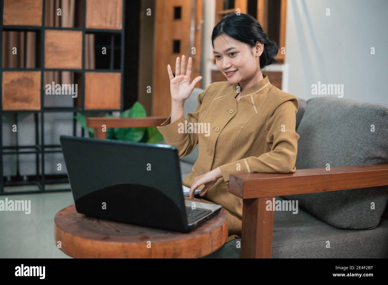 woman in civilian uniform use laptop while sitting with hand gestures ...