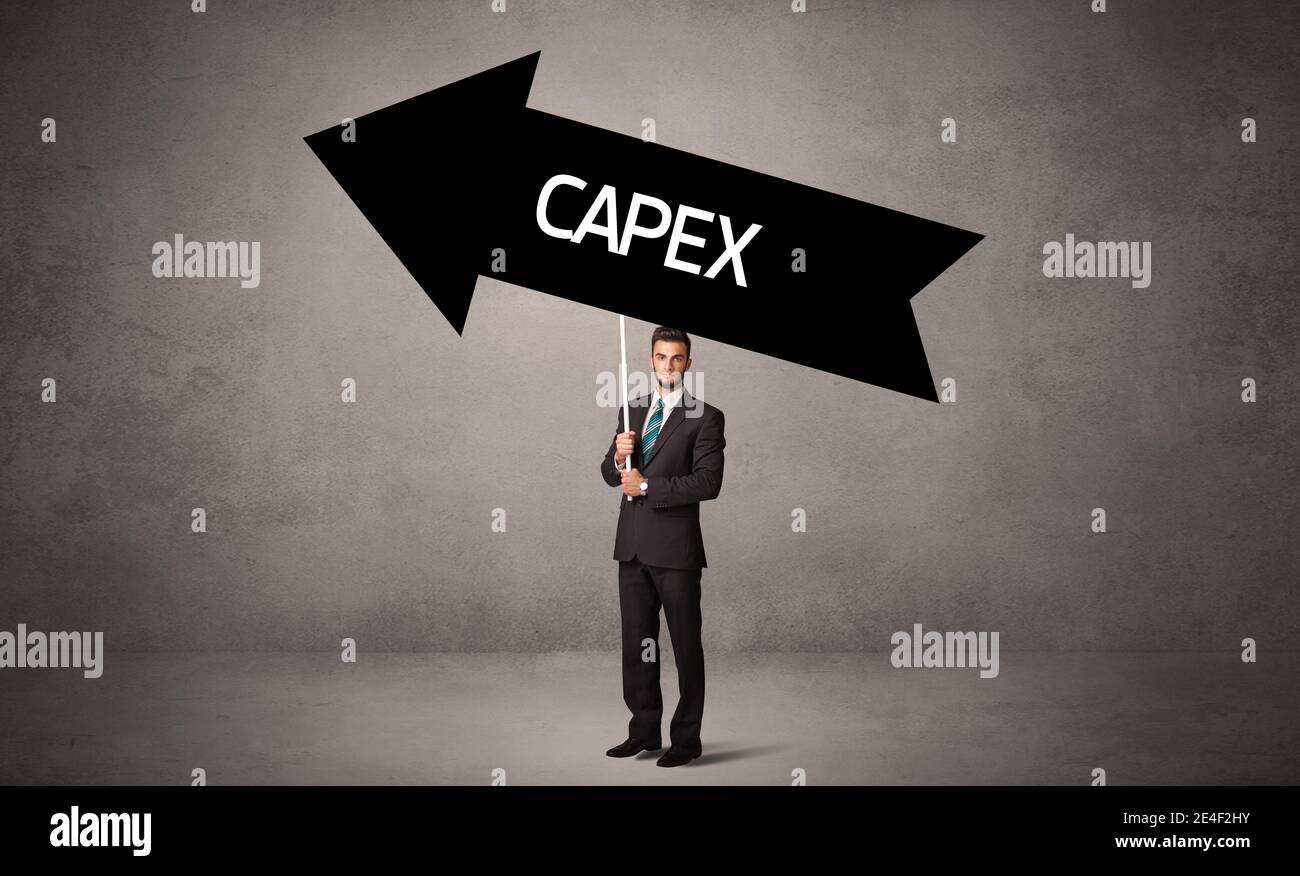 Young business person in casual holding road sign with CAPEX ...