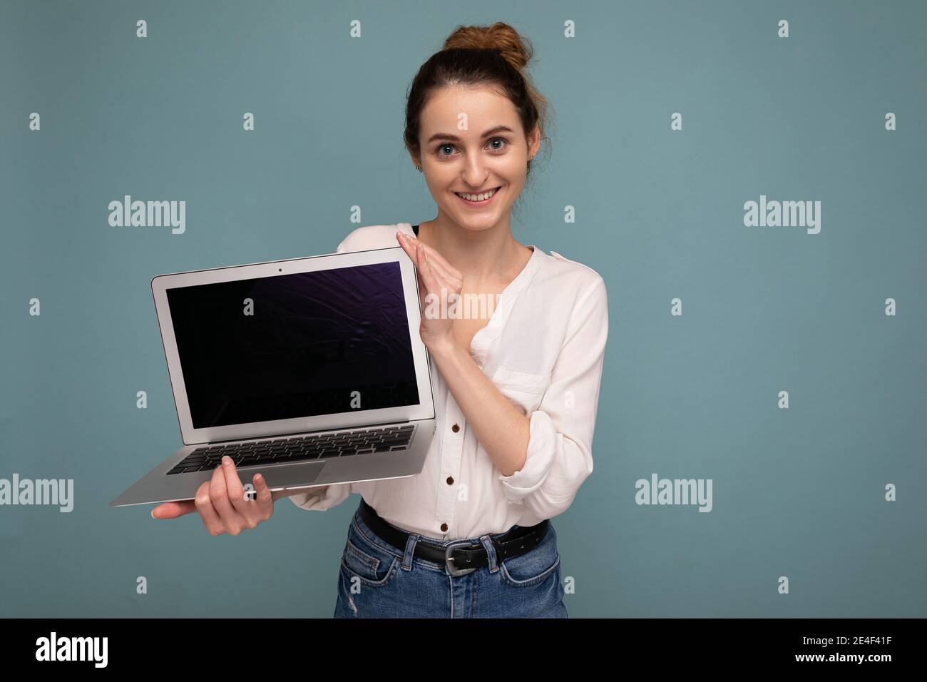 Beautiful smiling young woman holding netbook computer looking at ...