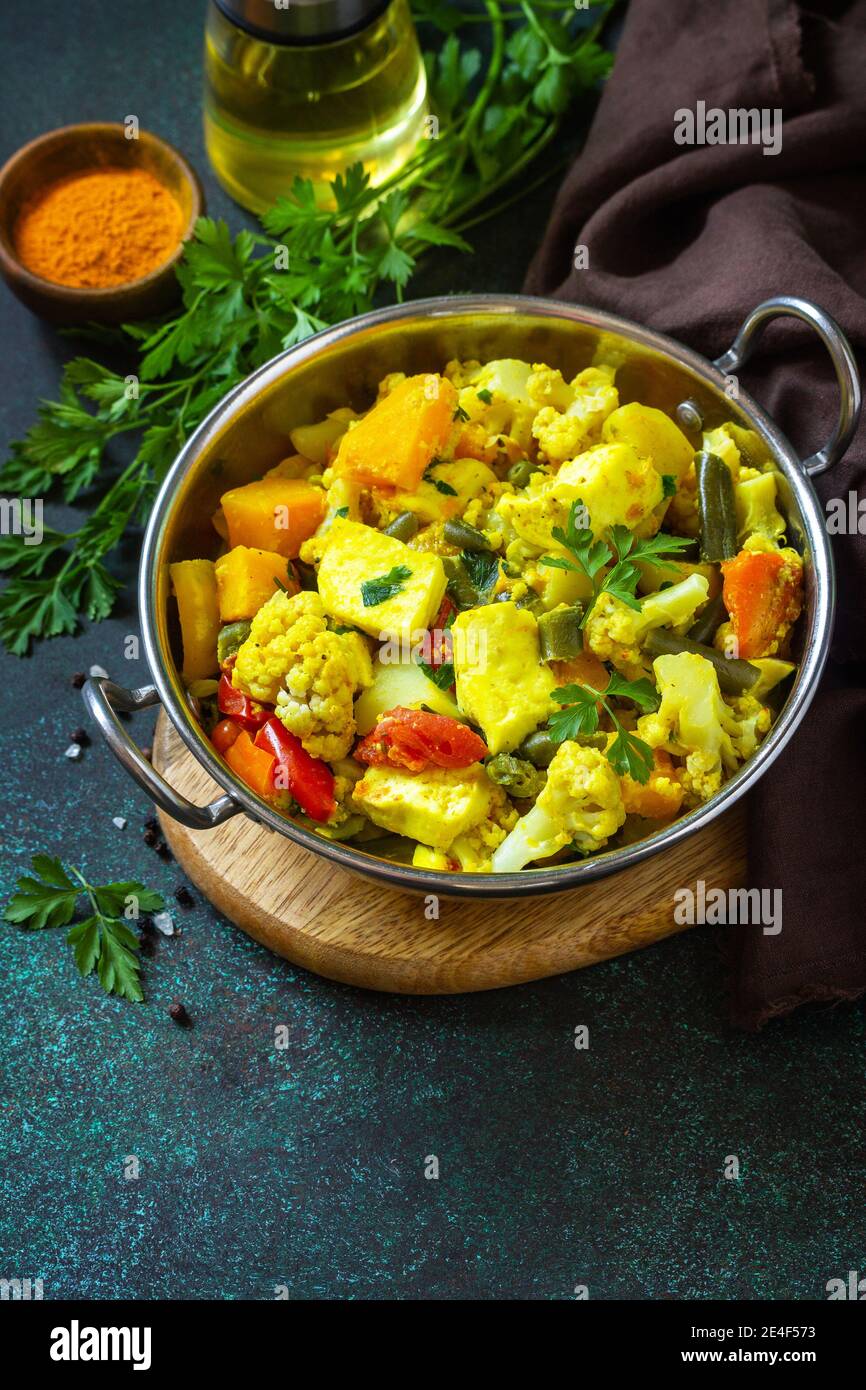 Sabji, Stewed pumpkin with soft cheese and vegetables on a dark stone ...