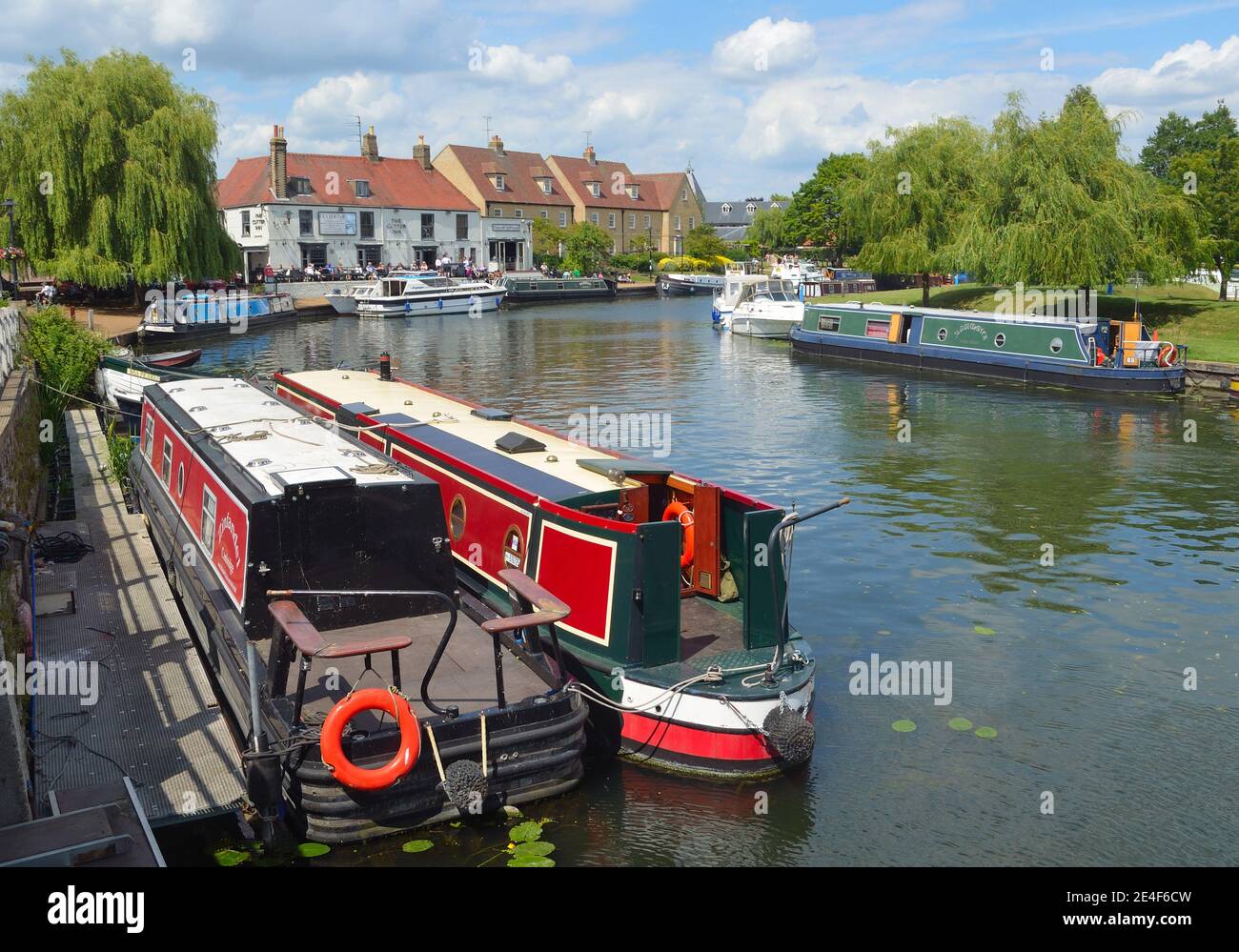 The river Ouse at Ely with narrow boats and waterside public houses and ...