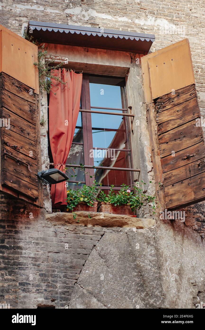 Italian window on the grey brick wall facade with opened brown color ...
