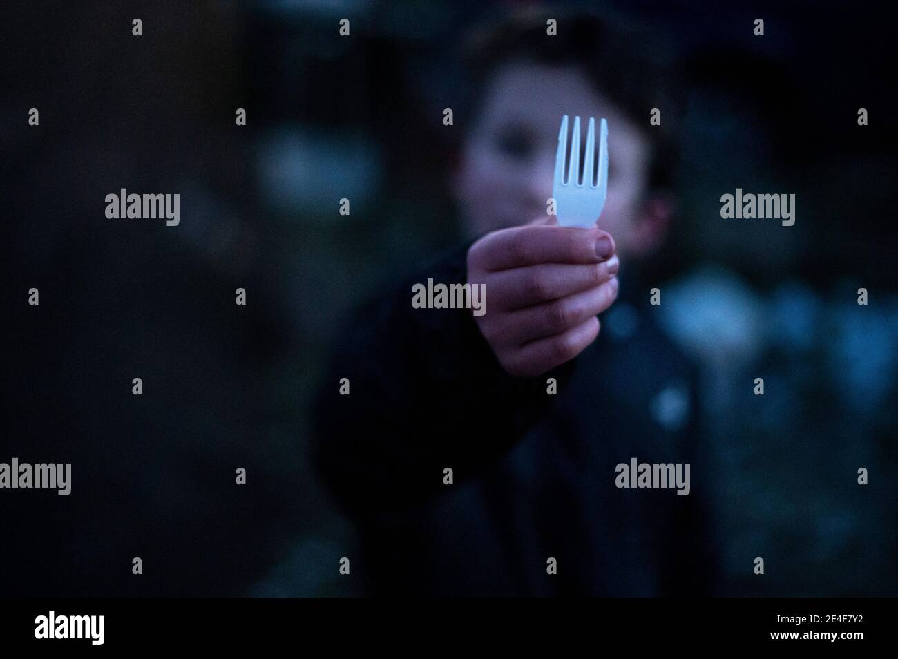 A young boy holds up a broken plastic spoon Stock Photo - Alamy