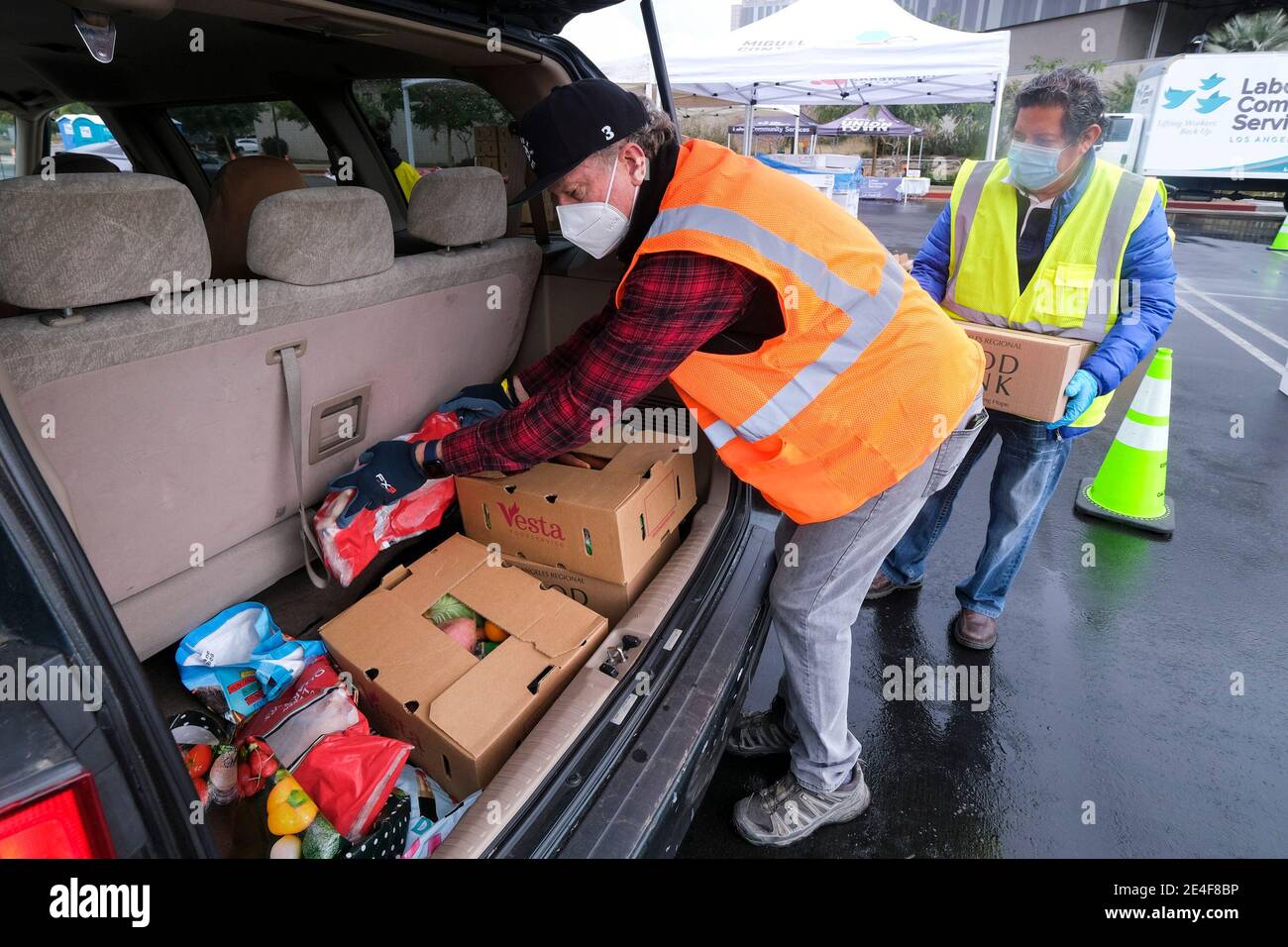 Los Angeles, California, USA. 23rd Jan, 2021. Volunteers load food into ...