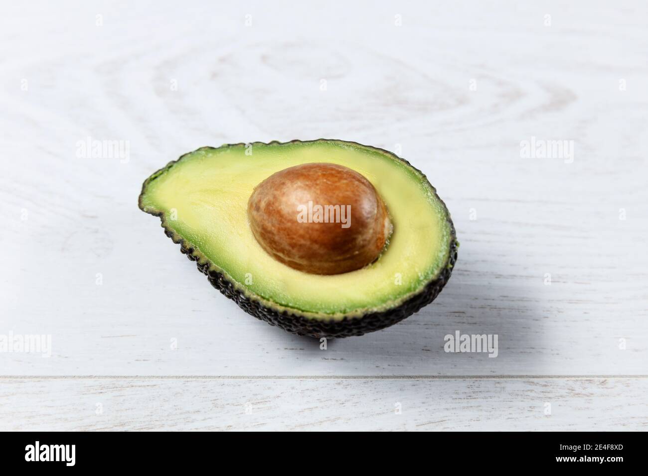 Avocado open on wooden table Stock Photo - Alamy