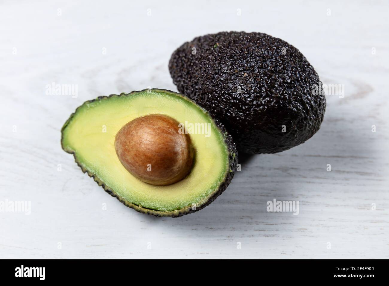 Avocado open on wooden table Stock Photo - Alamy