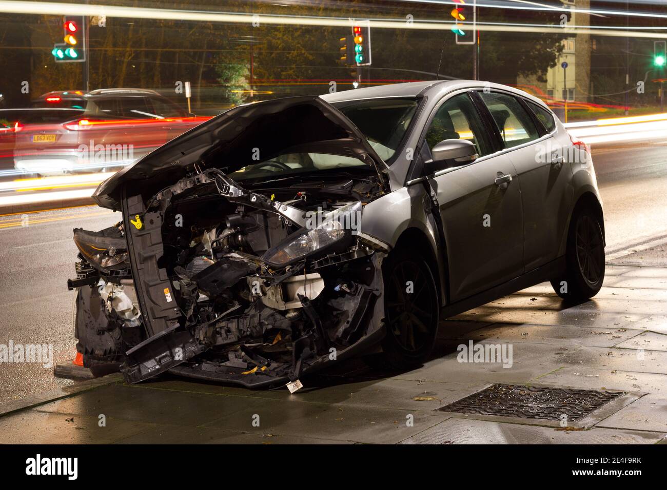badly damaged car abandoned on roadside at night on London street Stock ...