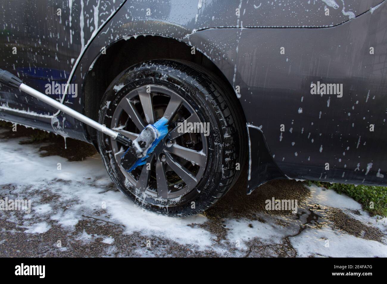 Concept of a car wash outdoor, washing a car with a brush with foam ...