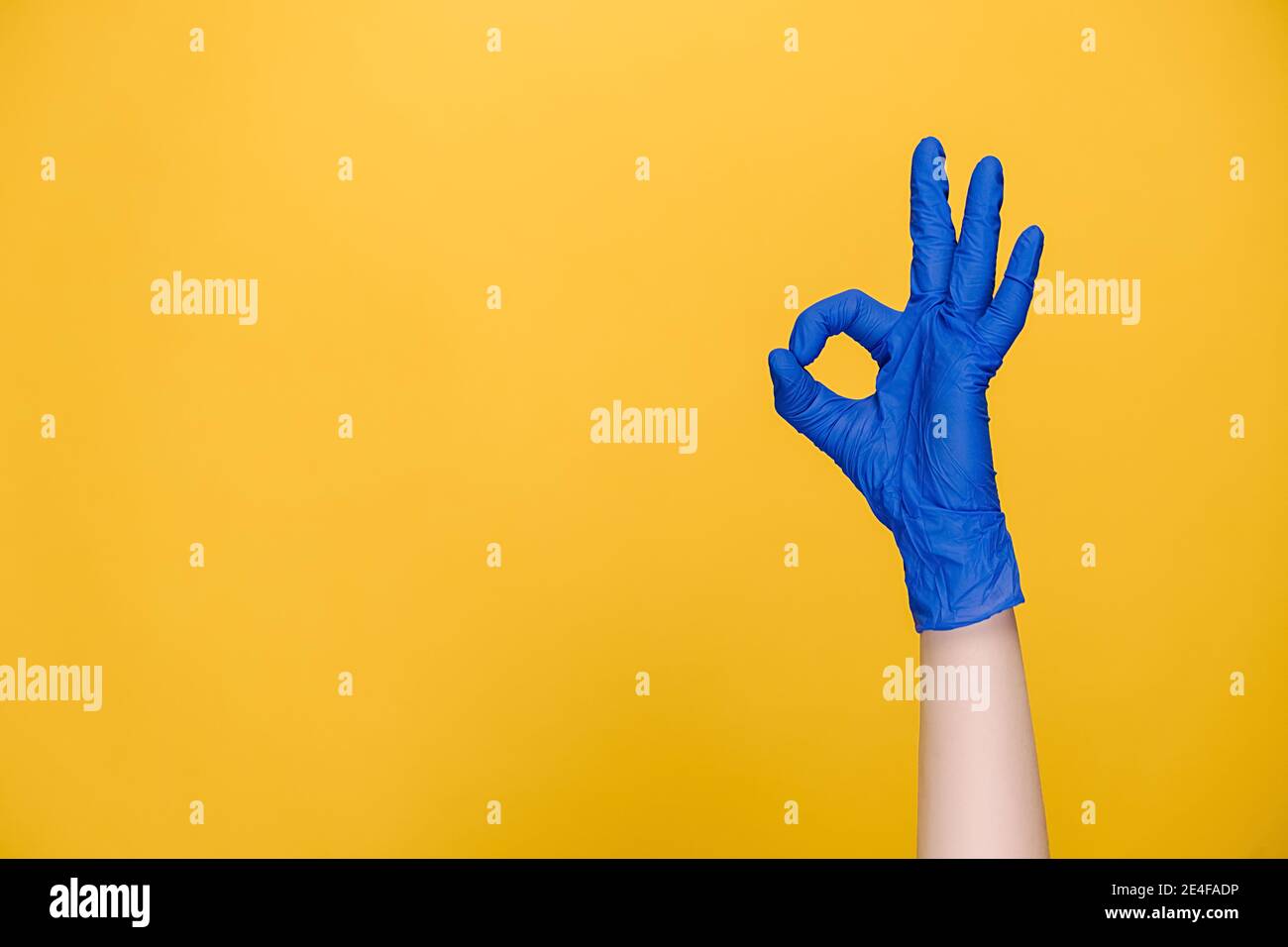 Closeup of male hand in medical protective gloves demonstrates ok sign ...