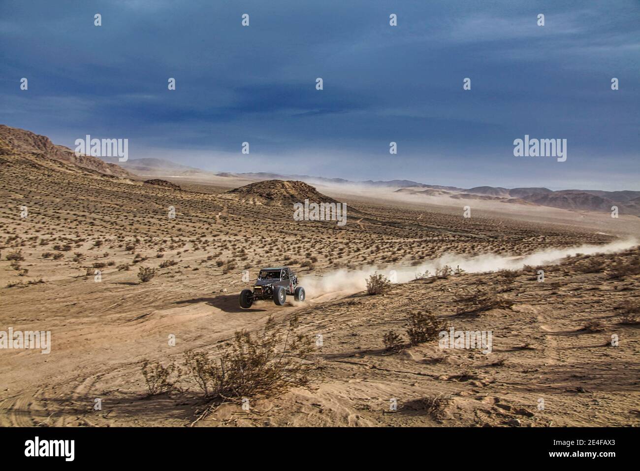 An ULTRA4 off road racing car careers though the desert during the ...
