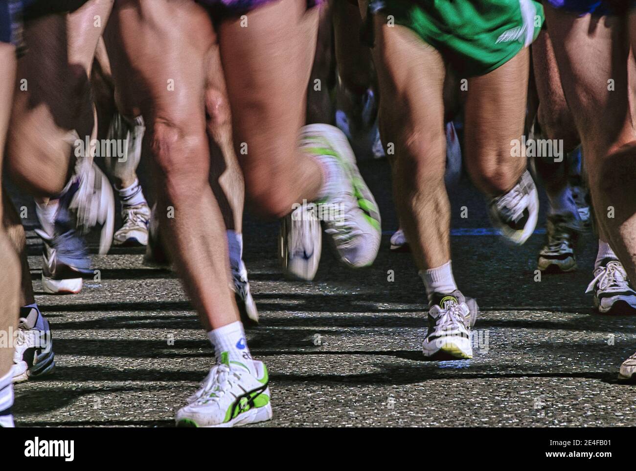 Blurred motion image of legs and feet of a group of people running, in ...