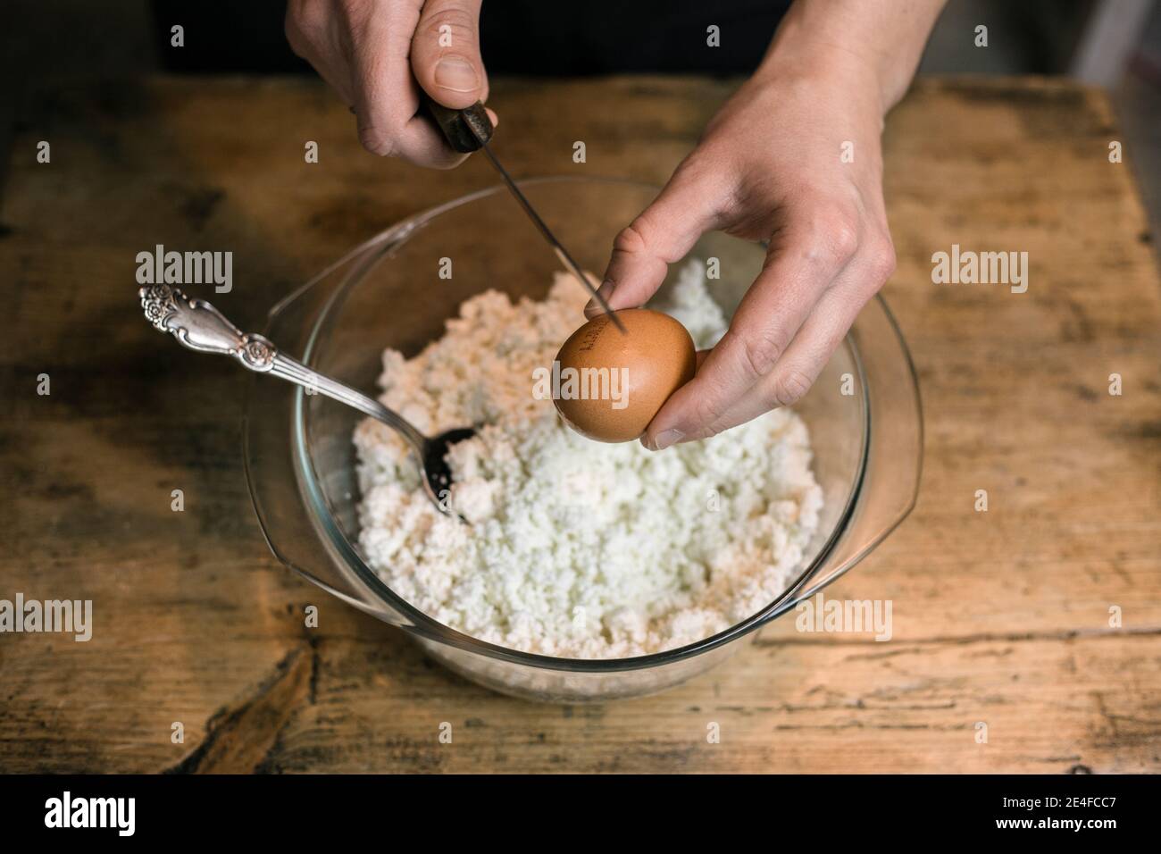 Breaks a chicken egg and adds to the curd Stock Photo - Alamy