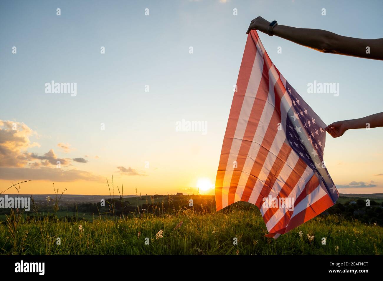 Human hands holding waving USA national flag in field at sunset Stock ...