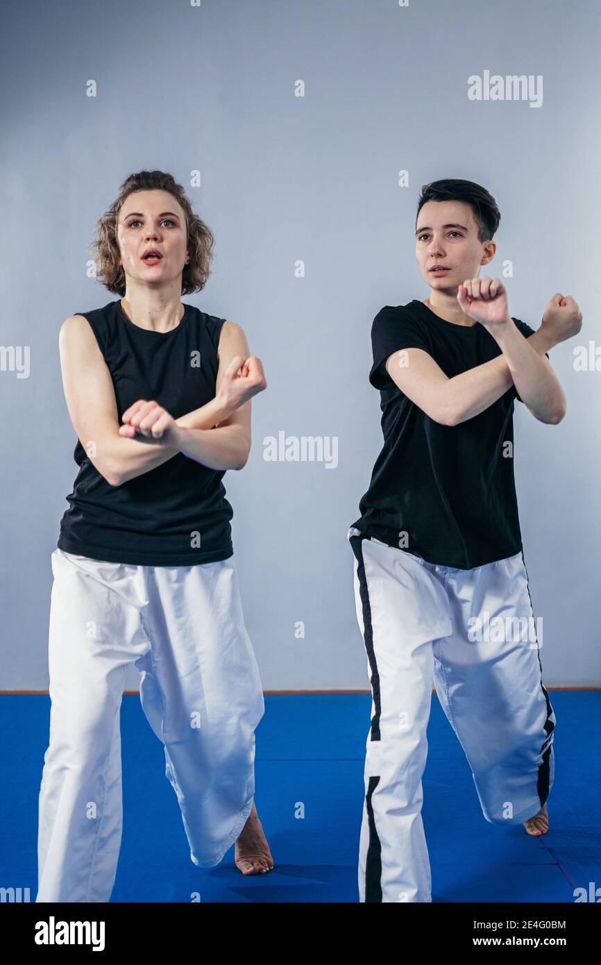 Two female fighter of martial arts practice in gym. Taekwondo coach and ...