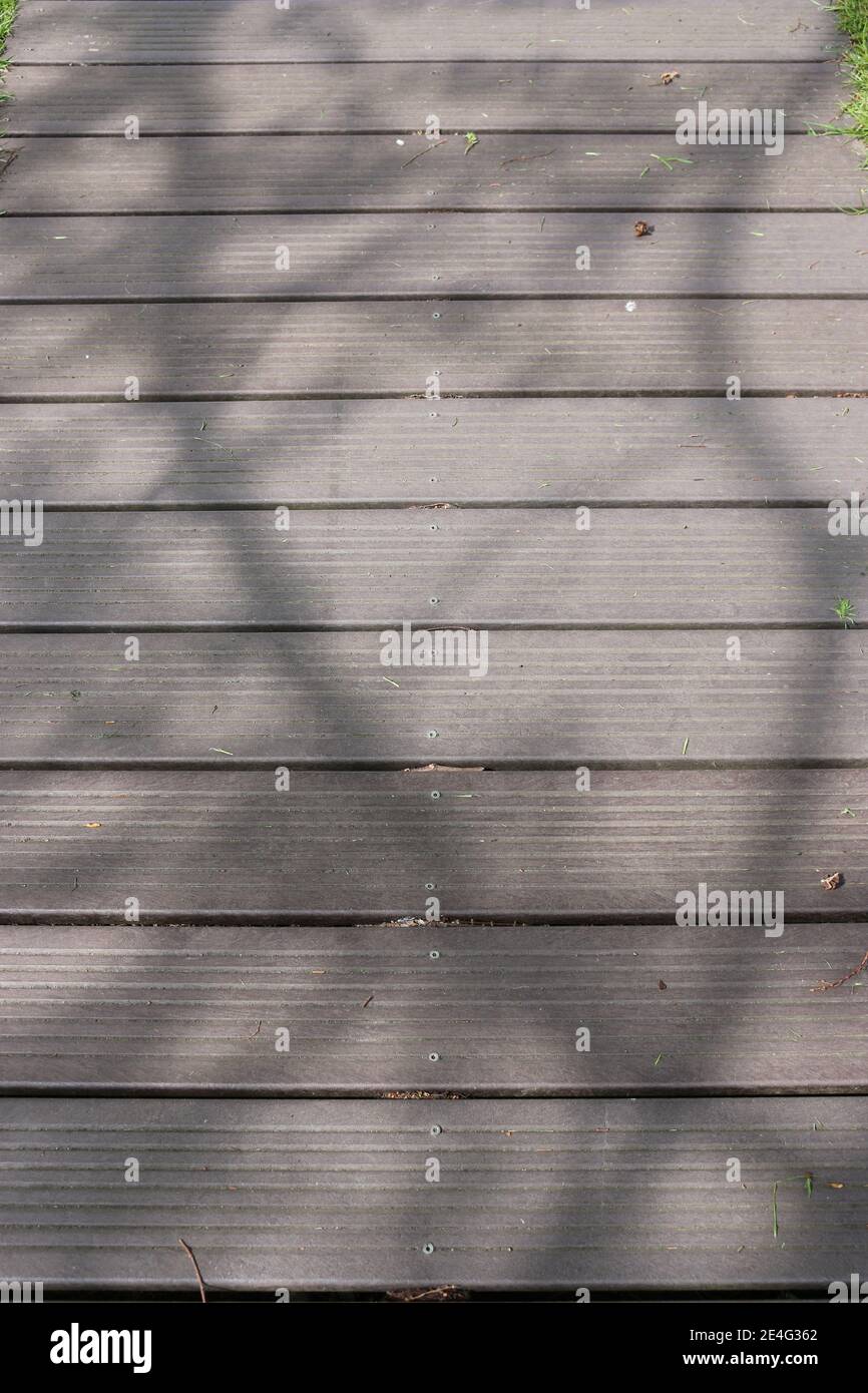 Recycled plastic surfaced boardwalk path with boards and gaps between ...