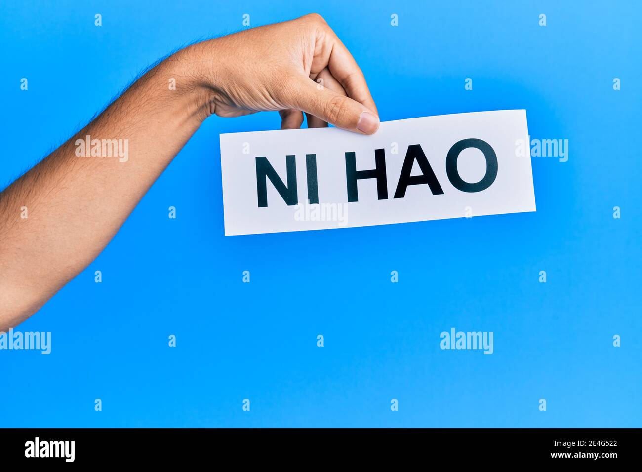 Hand of hispanic man holding chinese greeting ni hao word paper over ...