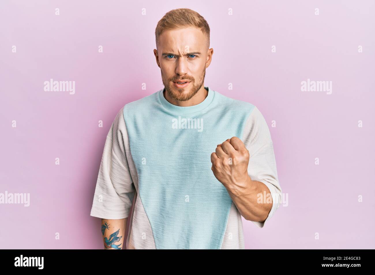 Young caucasian man wearing casual clothes angry and mad raising fist ...