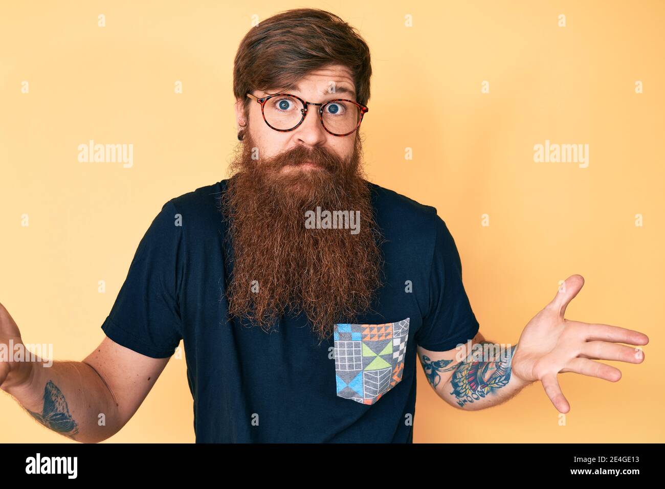 Handsome young red head man with long beard wearing casual clothes and ...