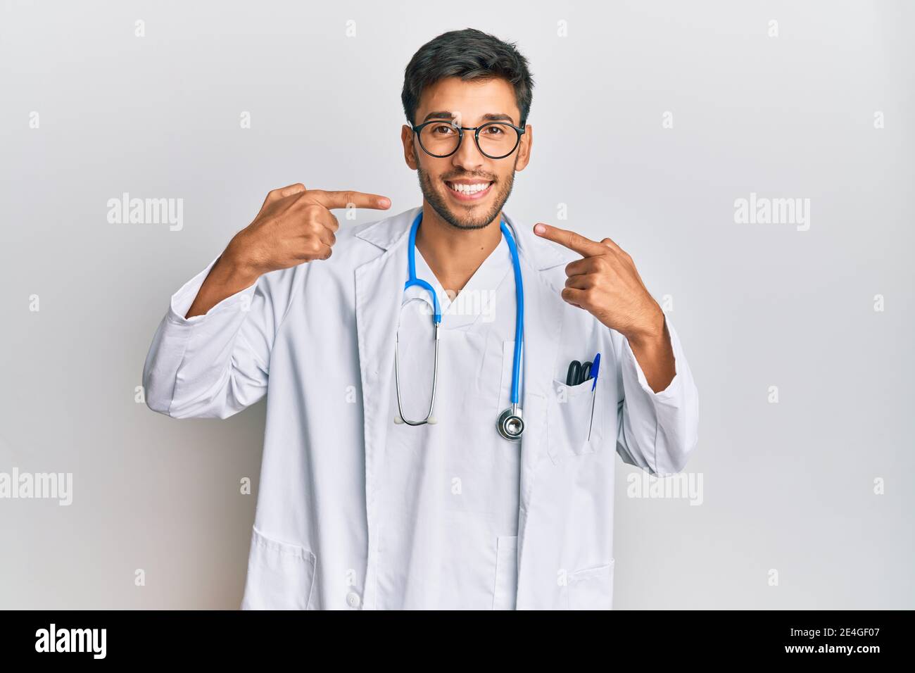Young handsome man wearing doctor uniform and stethoscope smiling ...