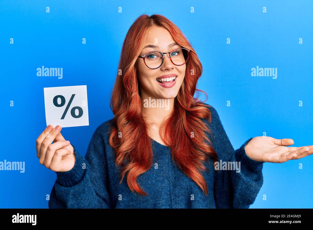 Young beautiful redhead woman holding percentage symbol celebrating ...