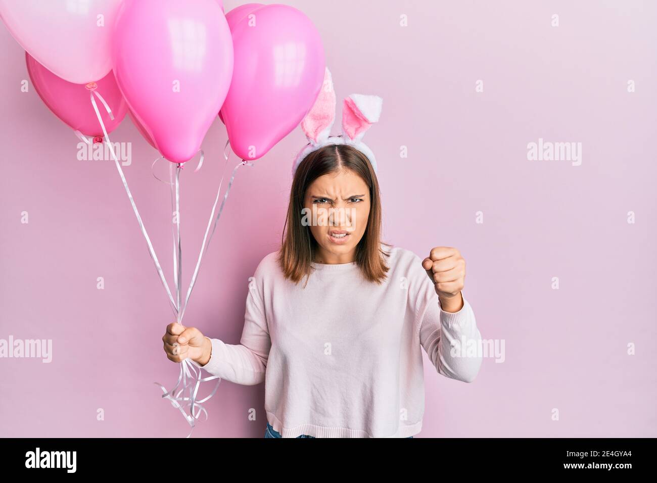 Young beautiful woman wearing cute easter bunny ears and holding ...