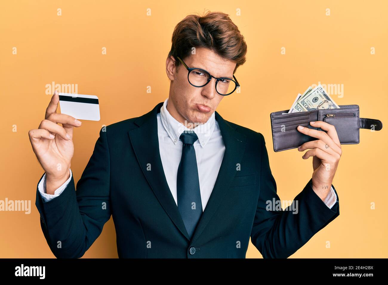 Handsome caucasian business man holding credit card and wallet with ...