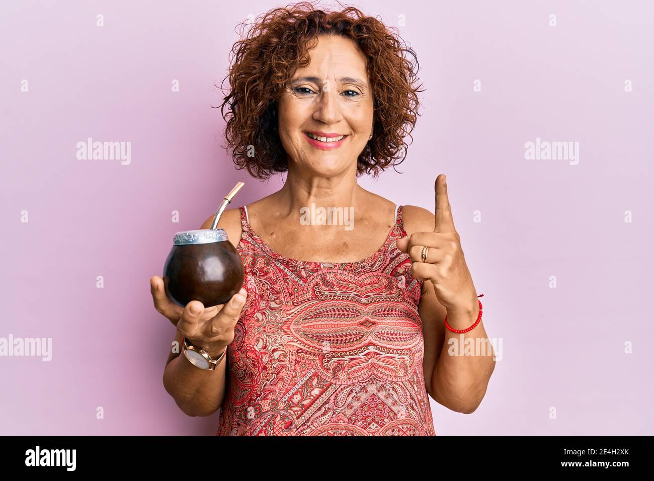 Beautiful middle age mature woman drinking mate infusion smiling with ...