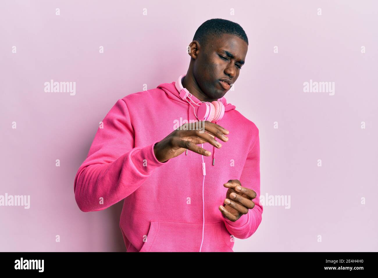 Young african american man wearing gym clothes and using headphones ...