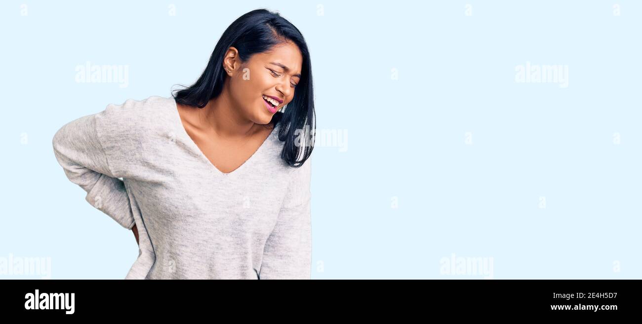 Hispanic woman with long hair wearing casual clothes suffering of ...