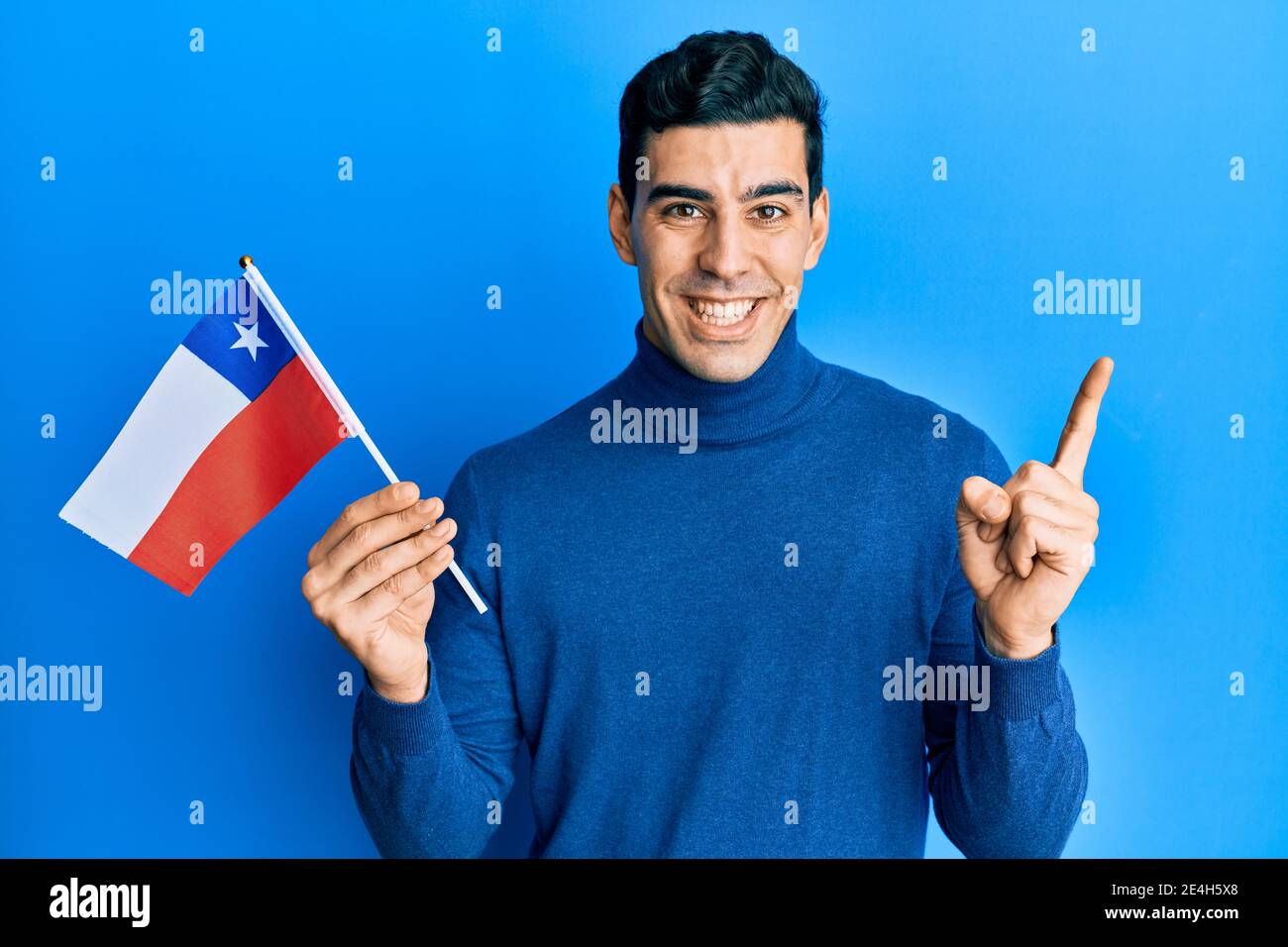 Handsome hispanic business man holding chile flag smiling happy ...