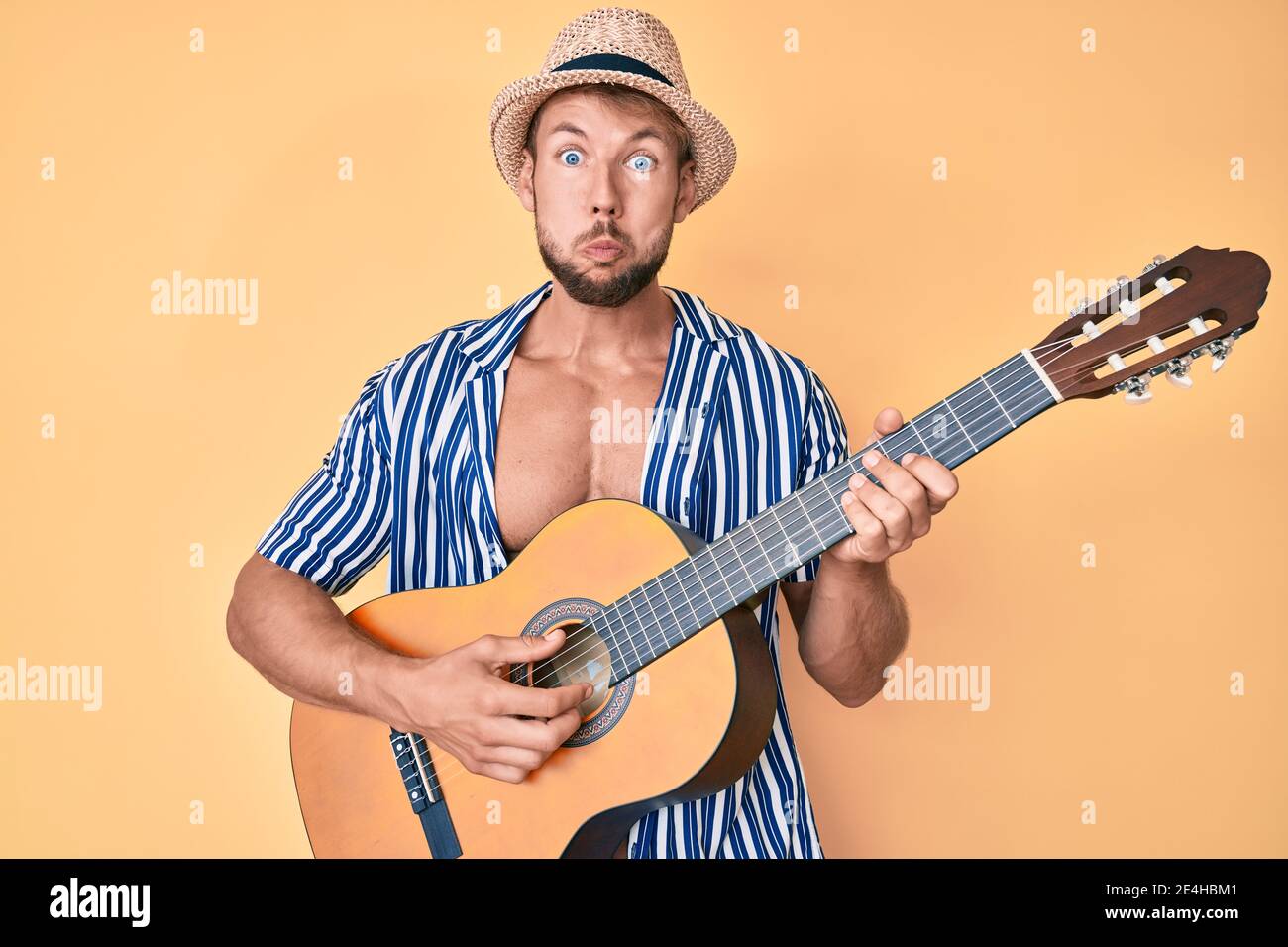Young caucasian man wearing summer style playing classical guitar ...