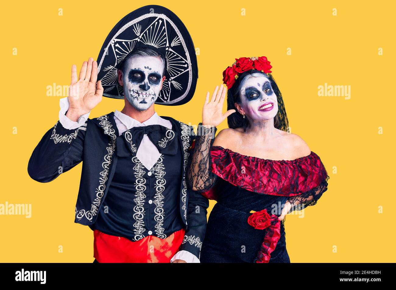 Young couple wearing mexican day of the dead costume over background ...
