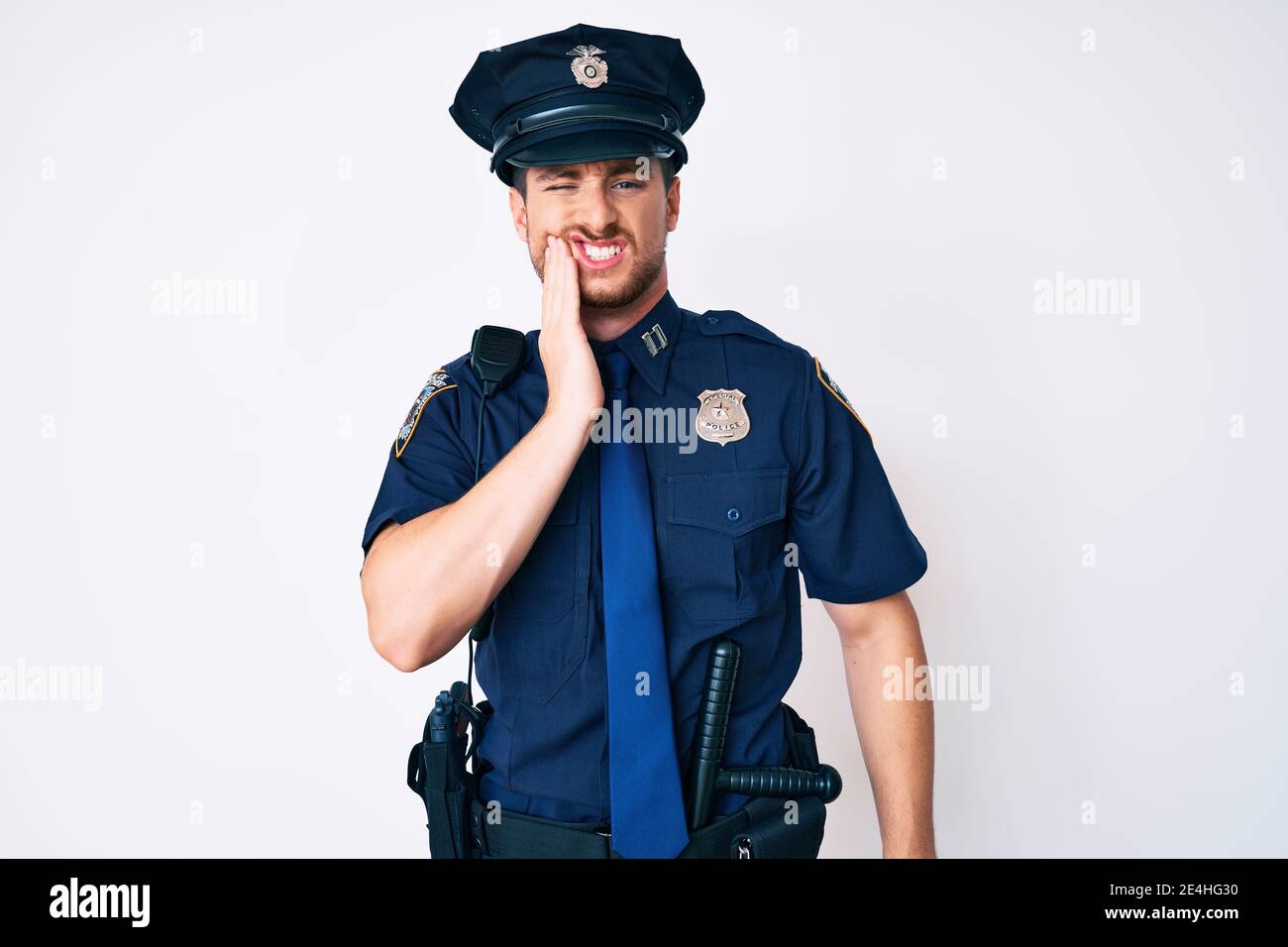 Young caucasian man wearing police uniform touching mouth with hand ...